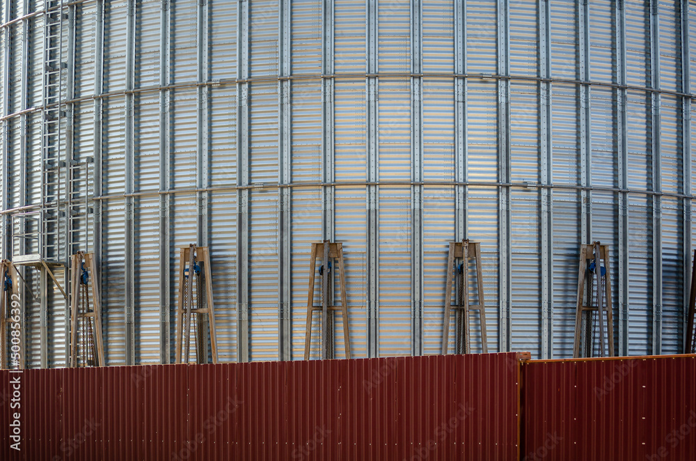 Industrial construction site. Construction of metal cylindrical silos ...