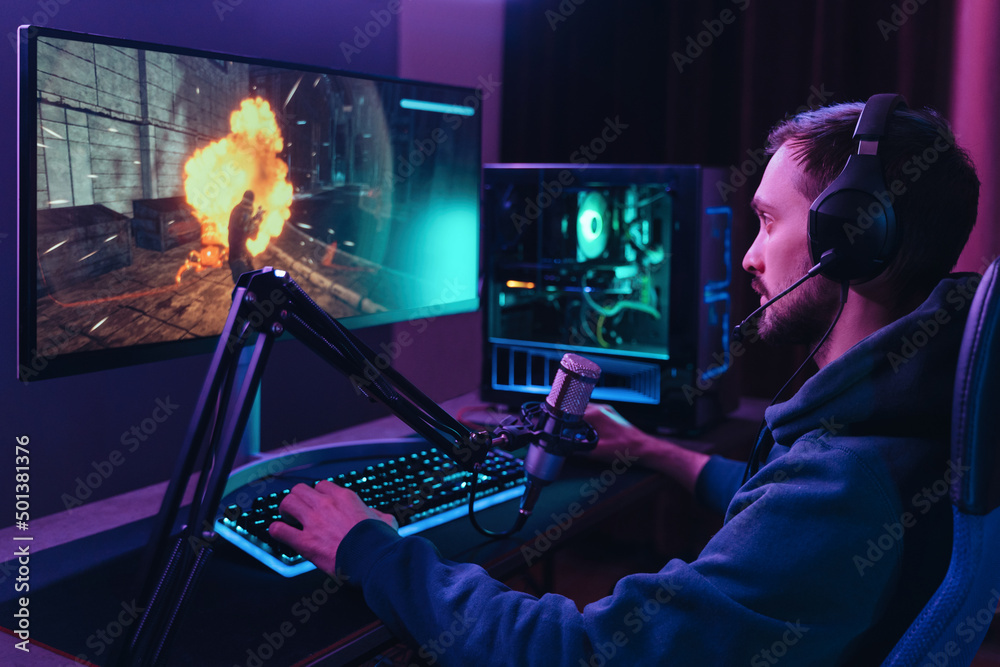 Concentrated young streamer man winning space shooter online ...