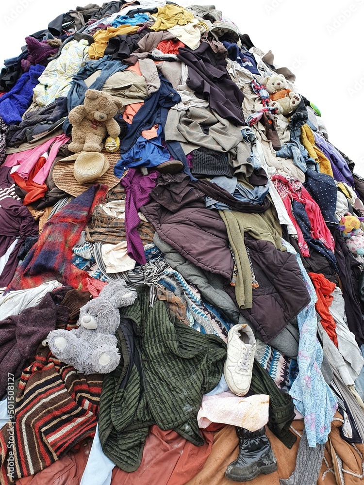 large pile stack of textile fabric clothes and shoes. concept of ...