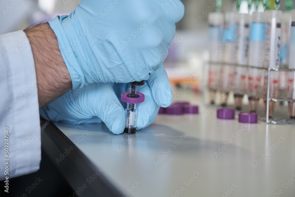 Scientist in white lab coat filter sample into HPLC vial. High ...