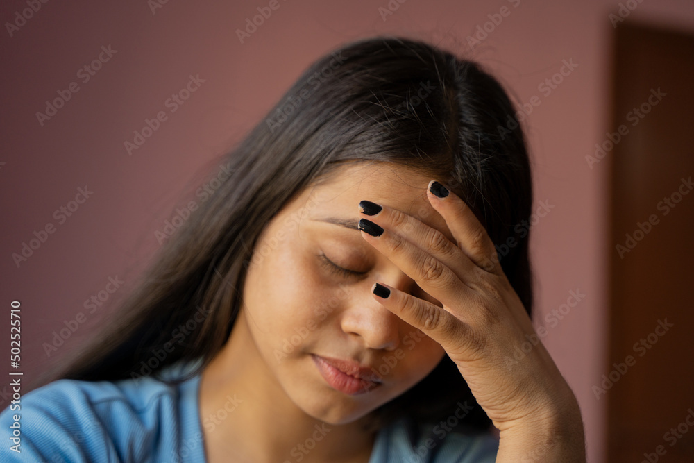 Sad tired young woman touching forehead having headache migraine or ...