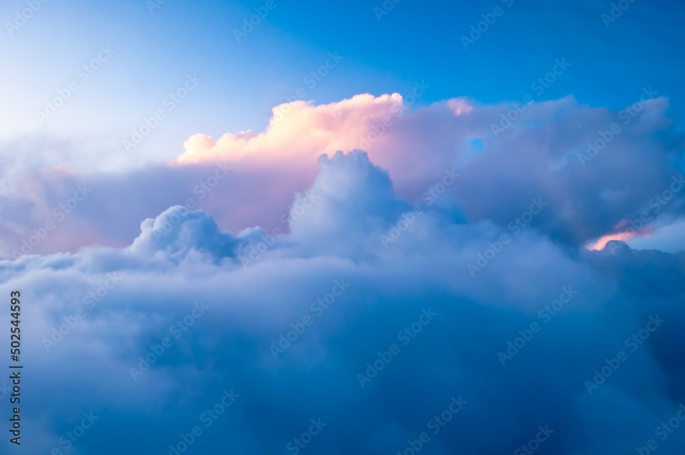 View of the pre-sunset cloudy sky through the porthole of the aircraft ...