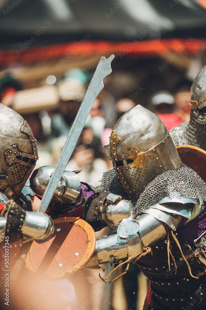 Pitch battle of medieval knights, using metal armor, axes, swords and ...