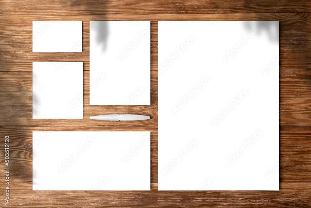 Mockup with various formats of corporate cards and folders on dark wood ...