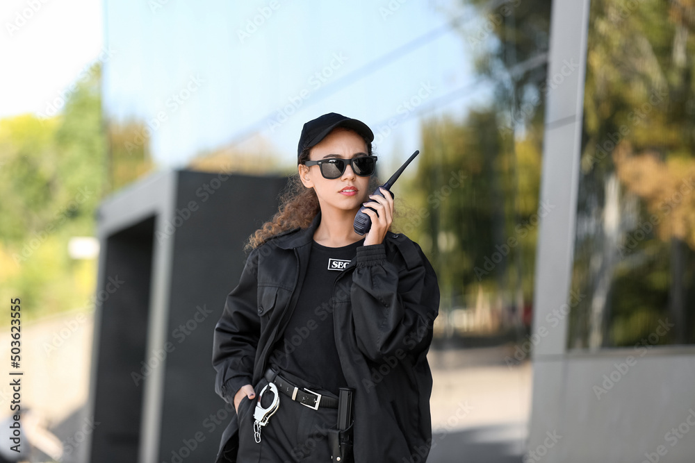 African-American female security guard with radio transmitter near ...