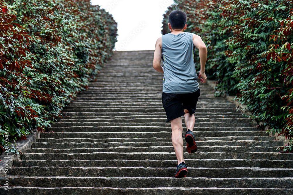 Rear view of young man running on stairs Stock Photo | Adobe Stock