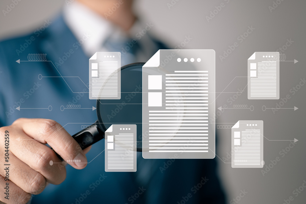 A man examines a paper with a magnifying glass. Business analysis ...