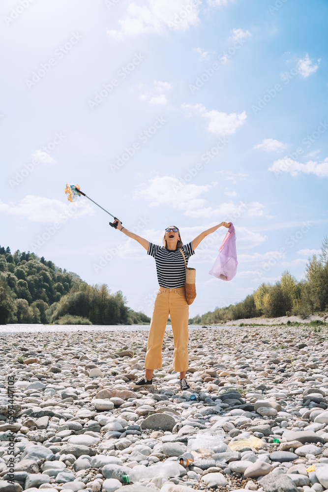 Person help to keep nature clean up and pick up garbage. Young woman ...