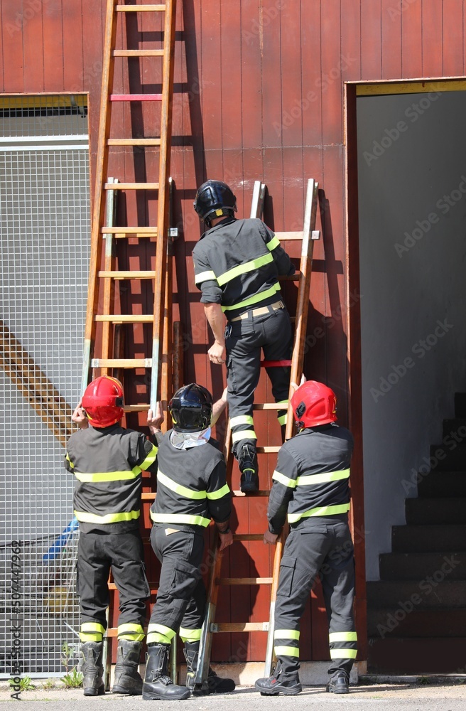 four firefighters in action during the exercise in the fire station ...