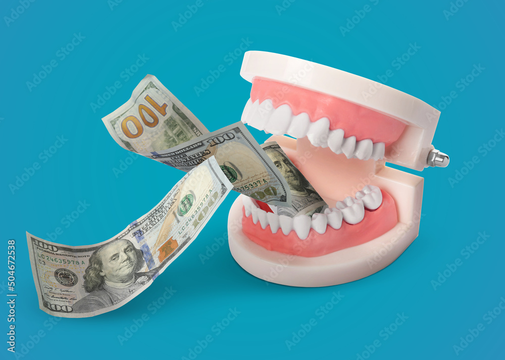 Model of oral cavity with teeth and dollar banknotes on turquoise ...