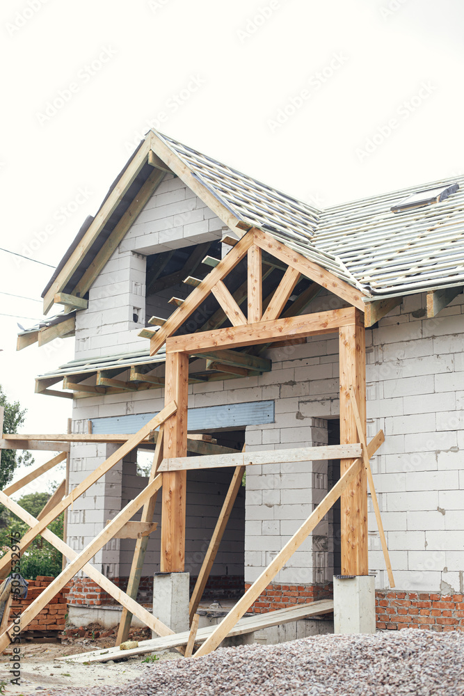 Unfinished modern farmhouse building. Wooden roof framing of mansard ...