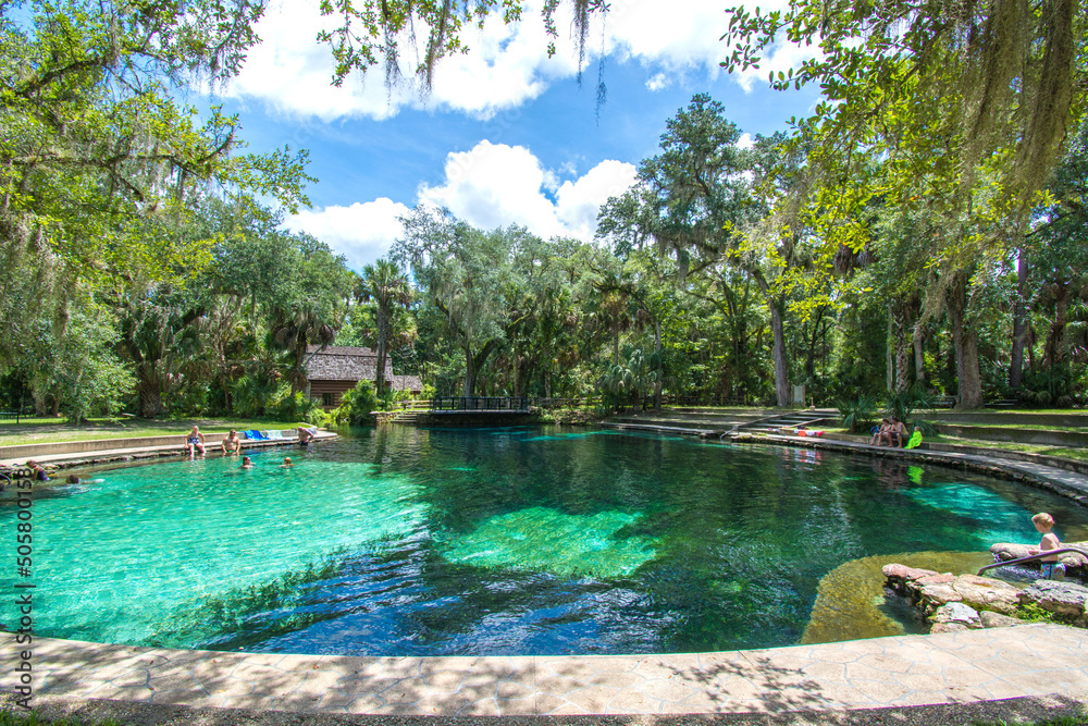 A family enjoying a cool dip in a natural fresh water springs swimming ...