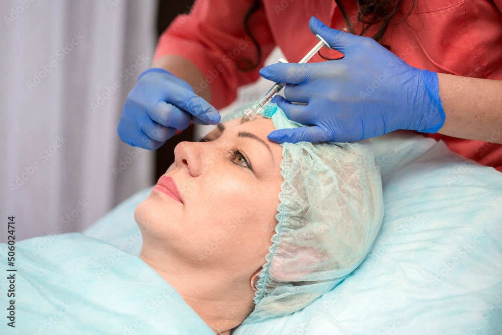 Injection facial rejuvenation. The cosmetologist injects cosmetic ...