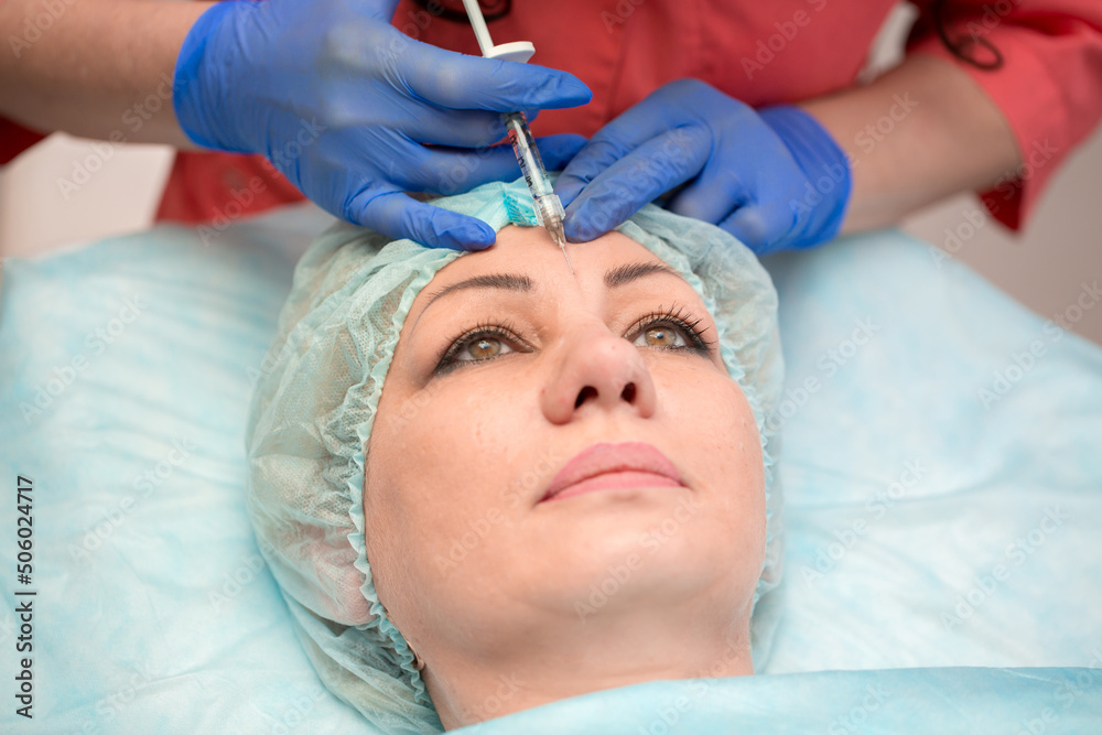 Injection facial rejuvenation. The cosmetologist injects cosmetic ...