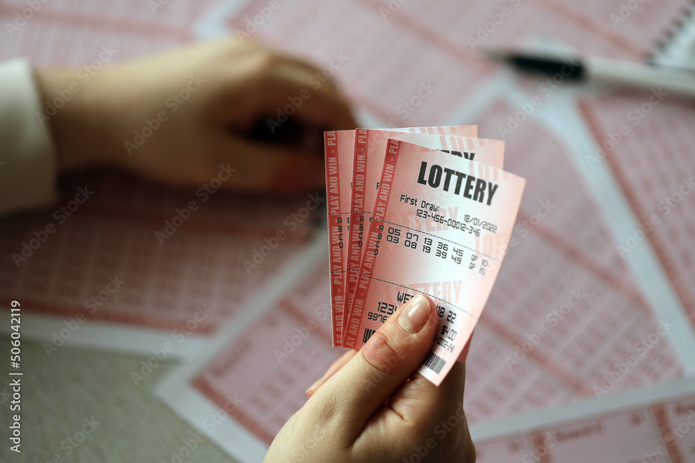 Filling out a lottery ticket. A young woman holds the lottery ticket ...