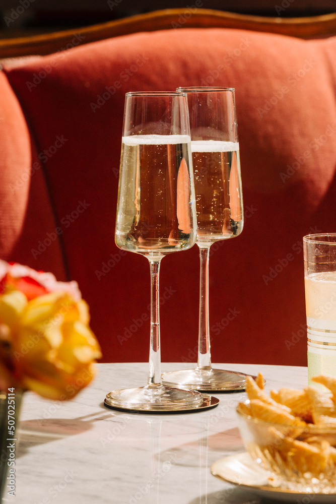 Prosecco flutes and snacks on a marbel table. Pink background Stock ...