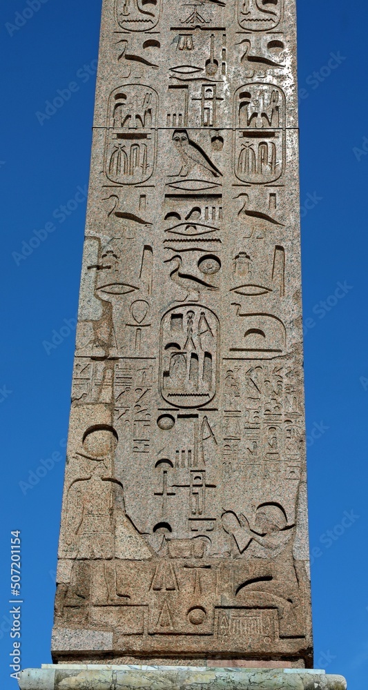 ancient Egyptian obelisk with hieroglyphics of various shapes and ...