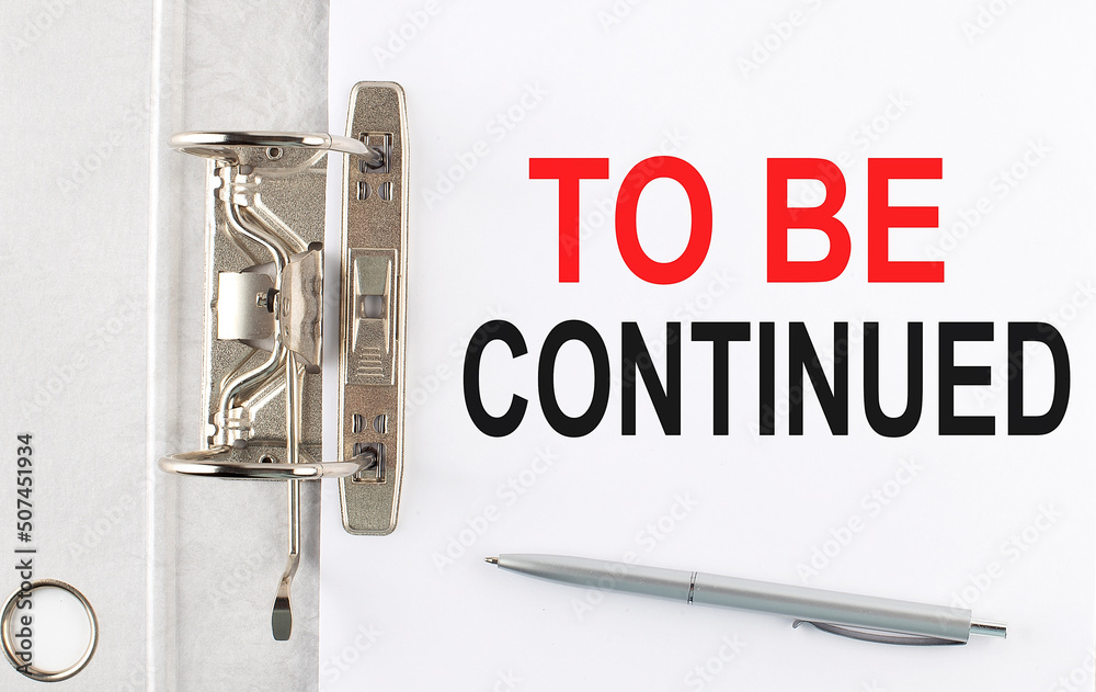 TO BE CONTINUED text on the paper folder with pen. Business concept ...
