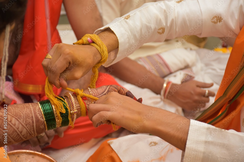 Groom Wearing Turmeric Thread On Bride Hand. Maharashtra Hindu Wedding ...