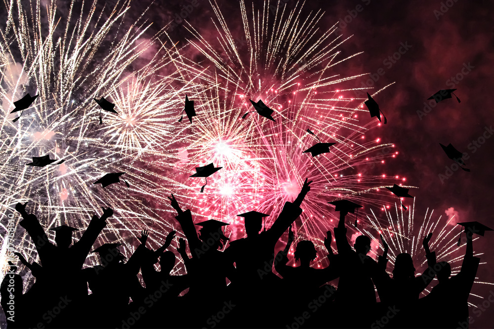 Graduation ceremony, fireworks in night sky. Silhouette of happy ...