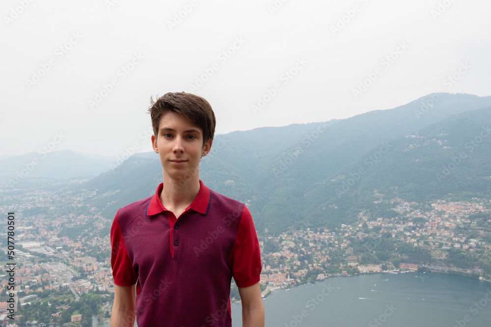 Handsome teen boy posing over great view with landscape of lake Como ...