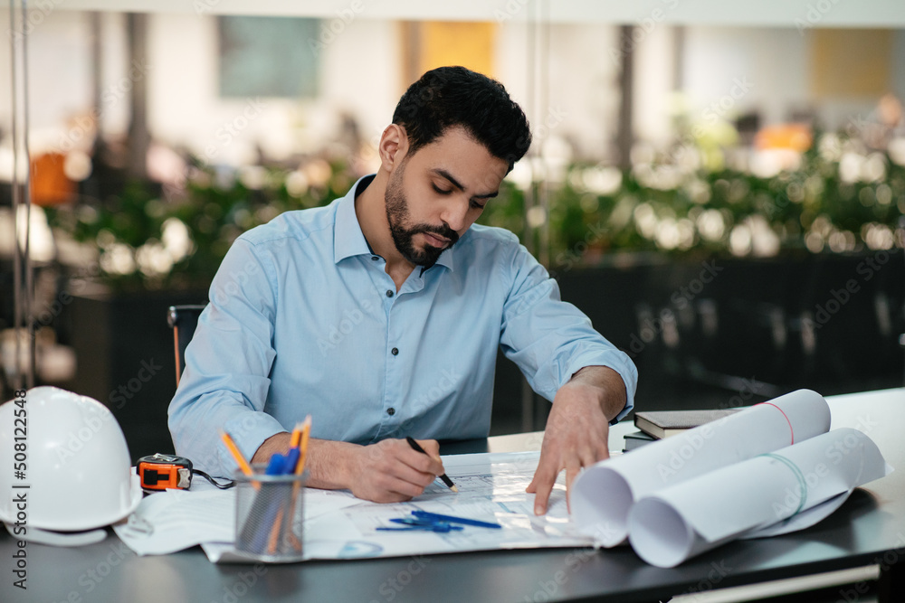 Serious smart busy young muslim man engineer architect with beard works ...