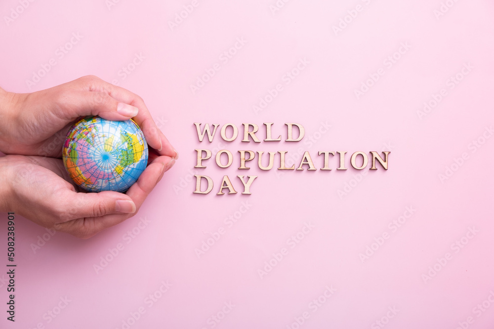 World population day write by wooden letter with globe in woman hands ...