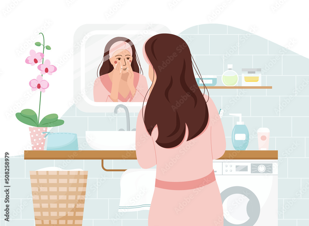 Morning routing. Young woman standing in front of mirror and cleansing ...