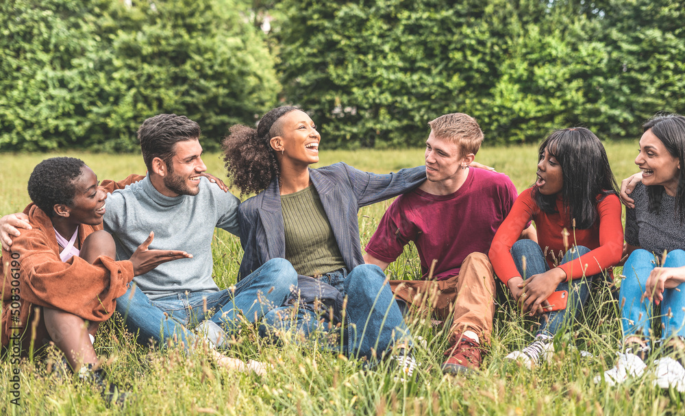 group of young people gathering together in the park while having fun ...
