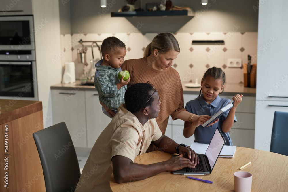 Portrait of multiethnic family with two kids in home interior black and ...