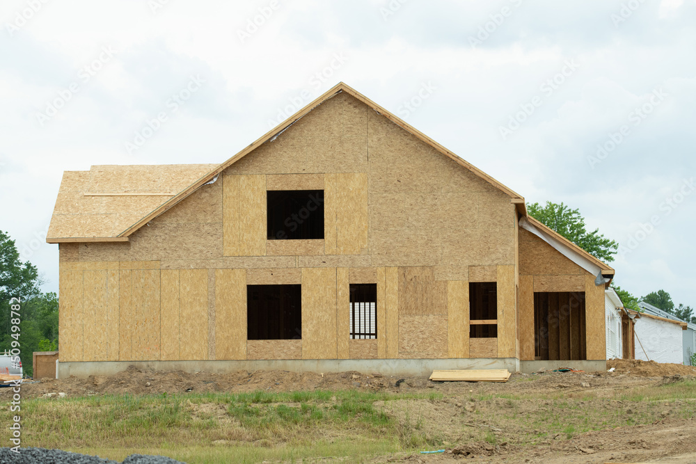 A residential house construction project showing plywood roof and ...