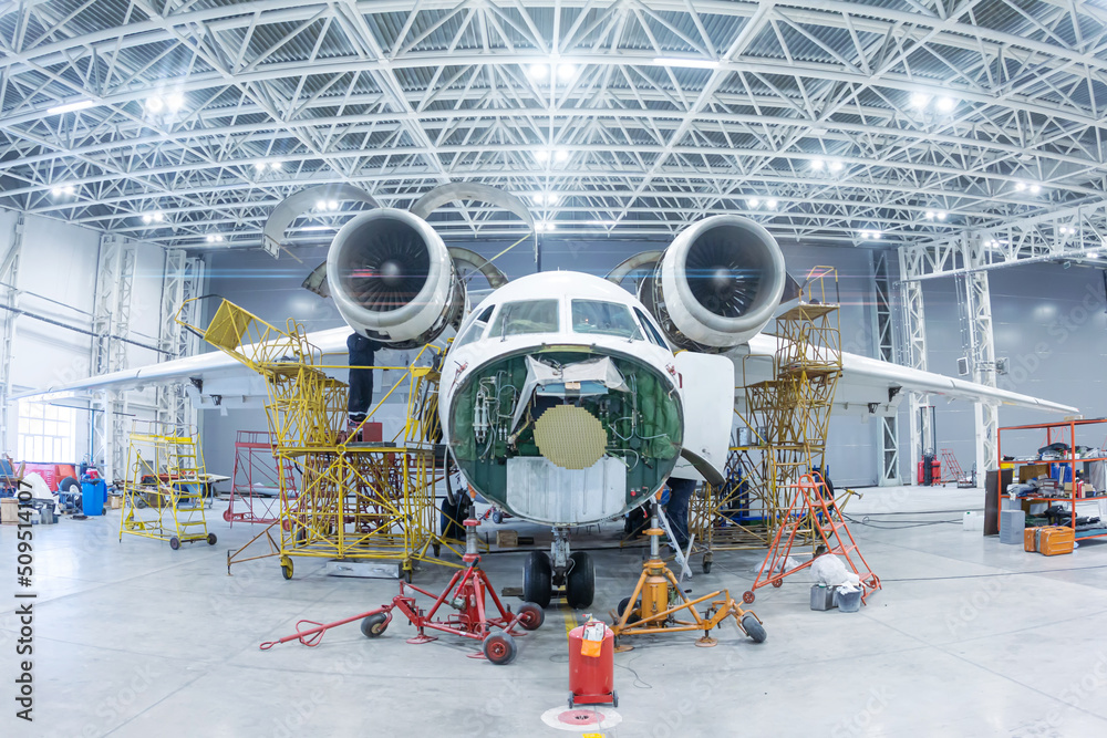 Front view of the white transport airplane in the hangar. Aircraft ...
