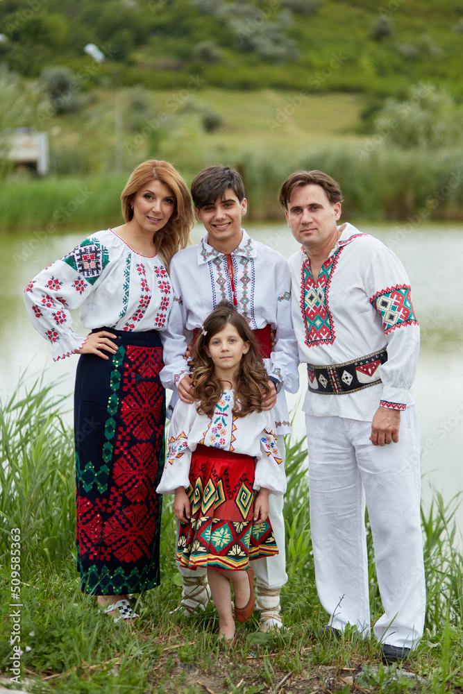 Happy family with kids in traditional romanian dress in a countryside ...