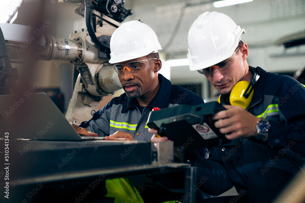 Factory workers working with adept robotic arm in a workshop . Industry ...