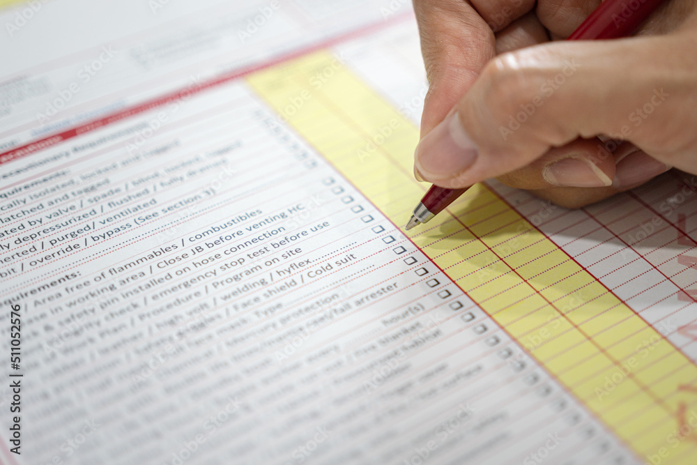 Action of safety officer is using a pen to marking checklist in work ...