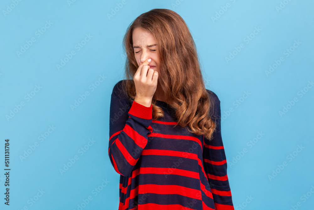 Stink, awful odor. Woman wearing sweater pinching nose, stop breathing ...