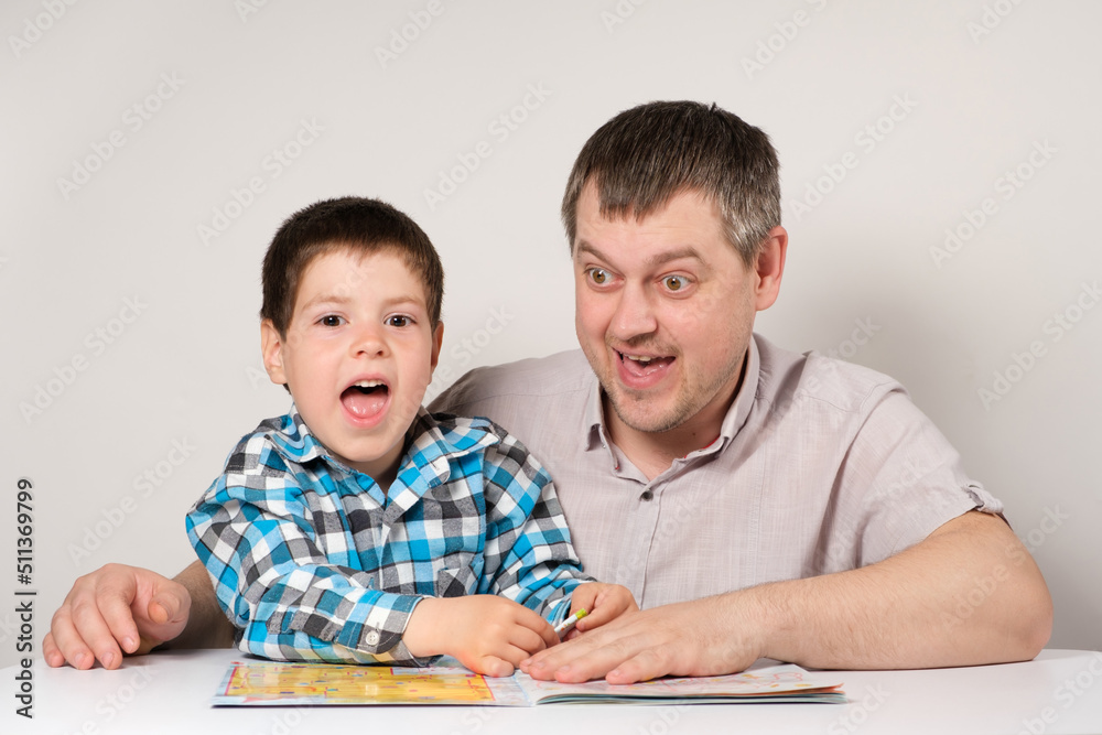 Dad teaches his son to read, names and write letters together. Parent ...