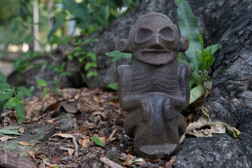 Taino Antique Stone Cemi Idol Figure sitting on the ground next to dry ...
