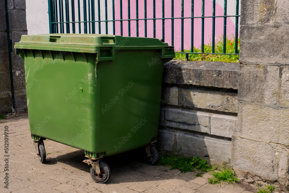 Green big size wheelie bin in a street. Garbage container ready for ...