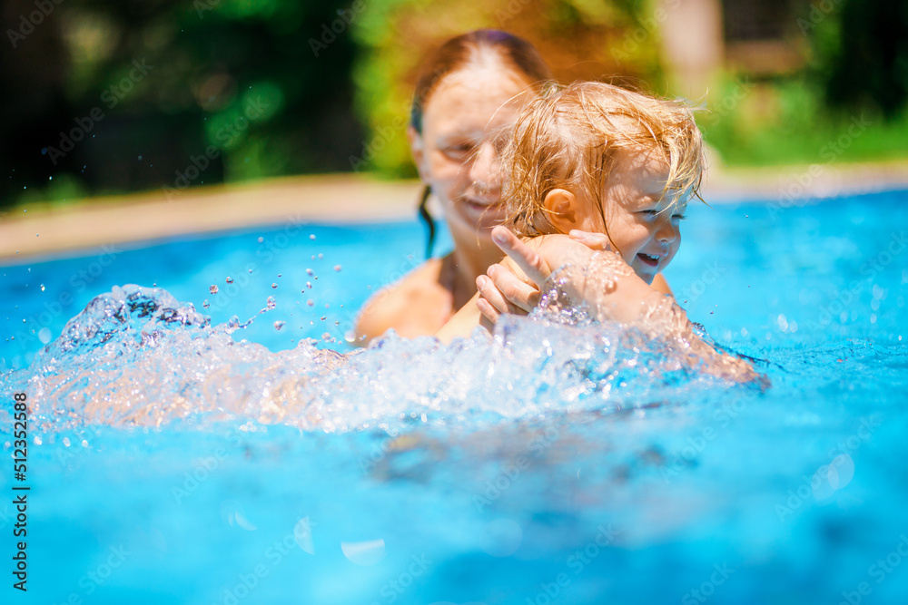 Mom and daughter in the pool. Summer outdoor fun in the pool in the ...