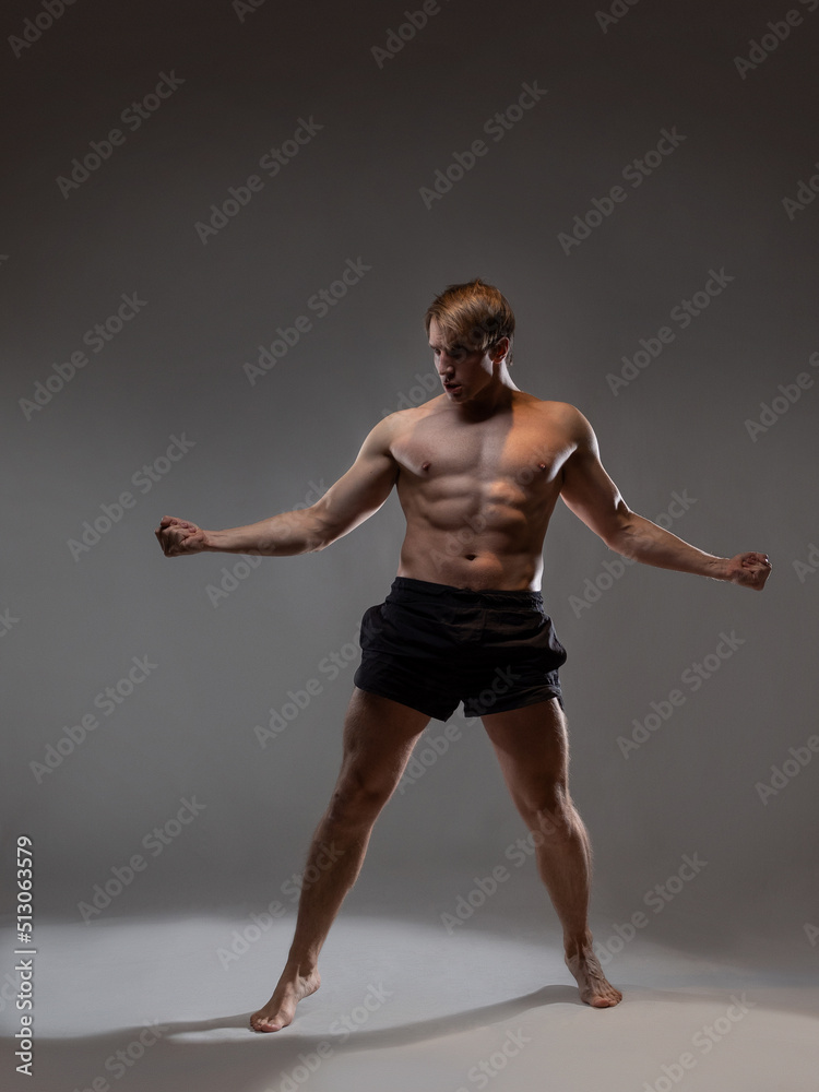 young muscular man in an expressive pose, artistic pose of the hero ...