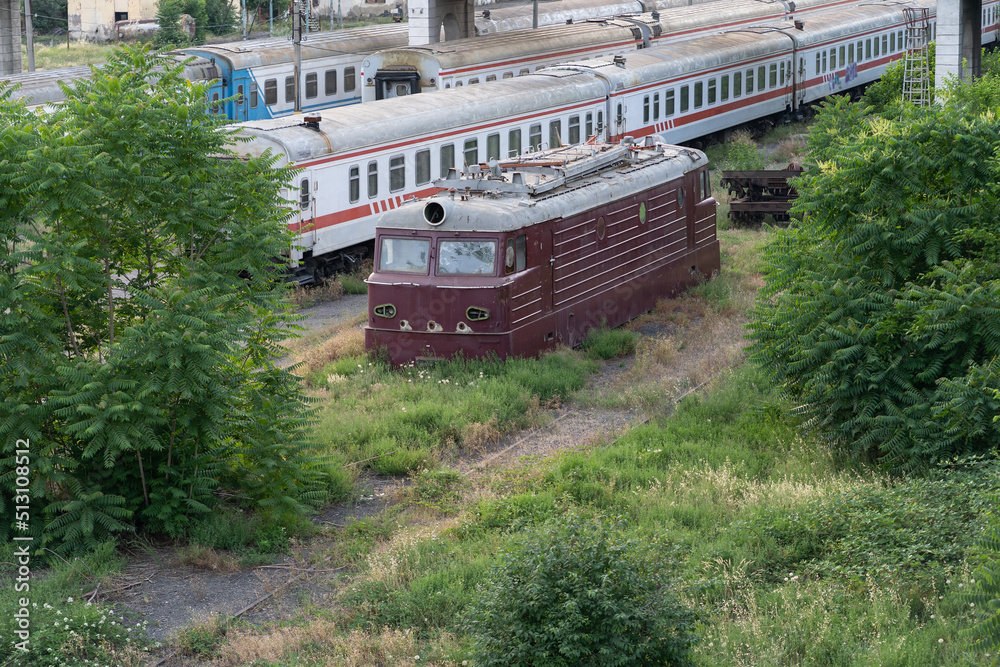 Abandoned soviet locomotive and passenger wagons on railroad tracks ...