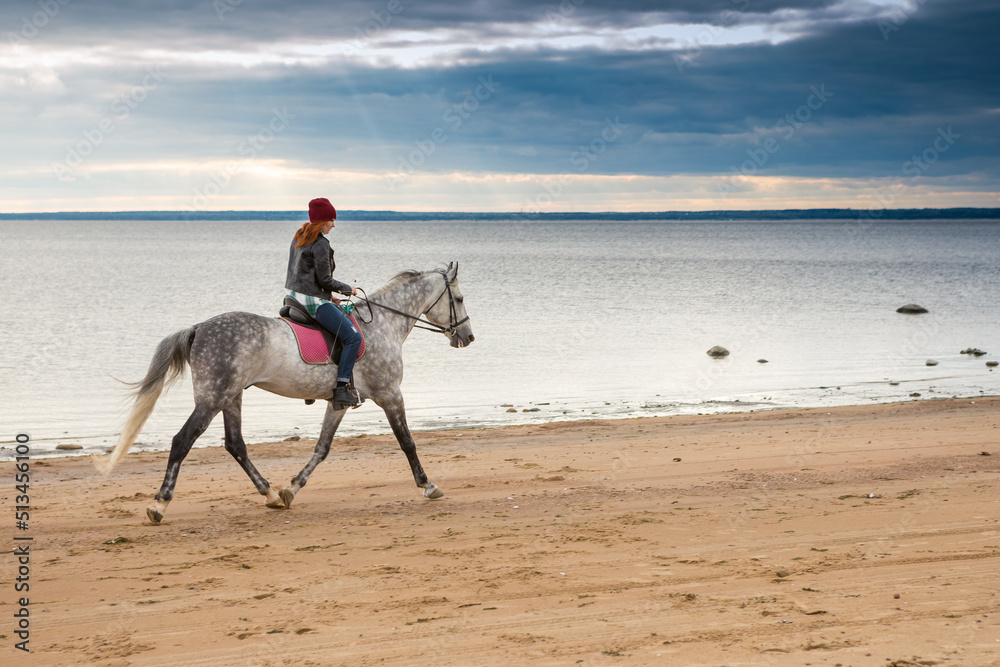 dressing jeans, jacket and fall hat female jokey rides astride a ...
