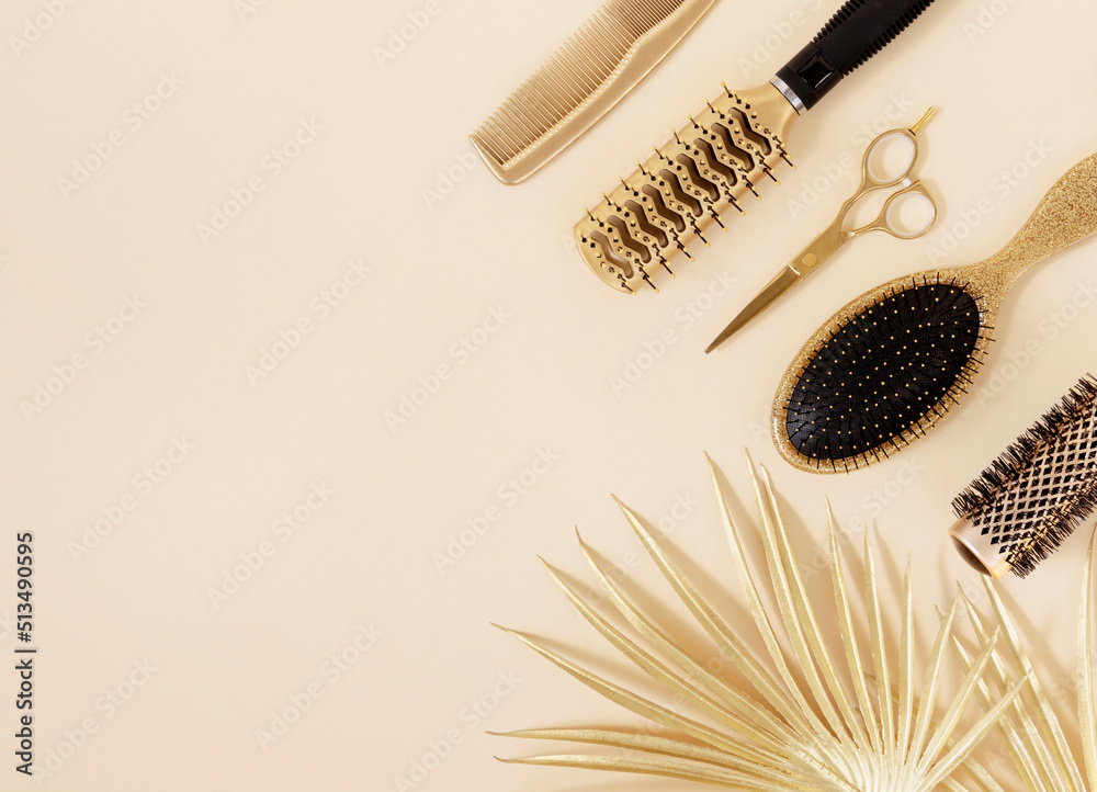 Hairdressing scissors and comb in gold color on a yellow background ...