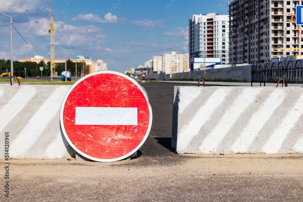 A stop road sign and concrete blocks block the entrance to the ...