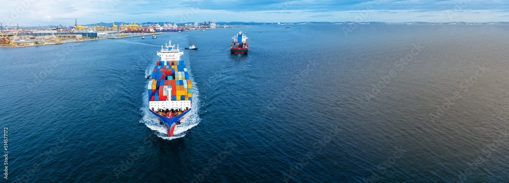 Aerial in front view of cargo ship carrying container and running for ...