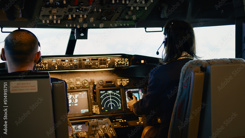 Team of captain and woman copilot fixing altitude and longitude to fly ...
