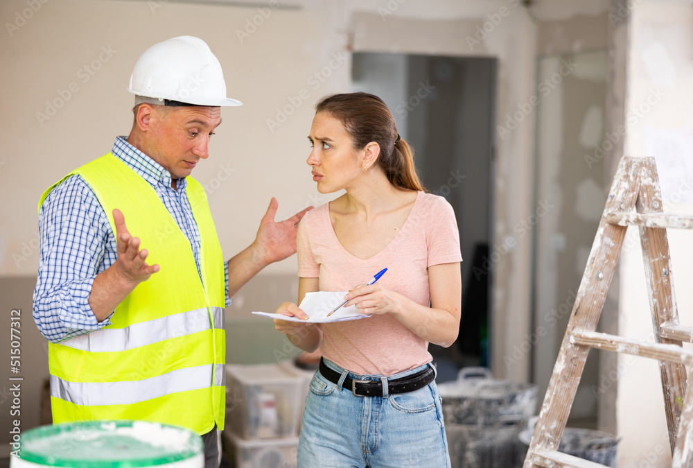 Frustrated young adult female designer arguing with male worker while ...