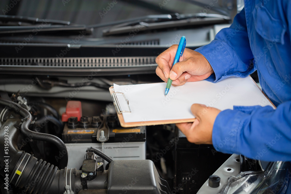 Auto mechanic holding clipboard checklist the car at mechanic shop ...