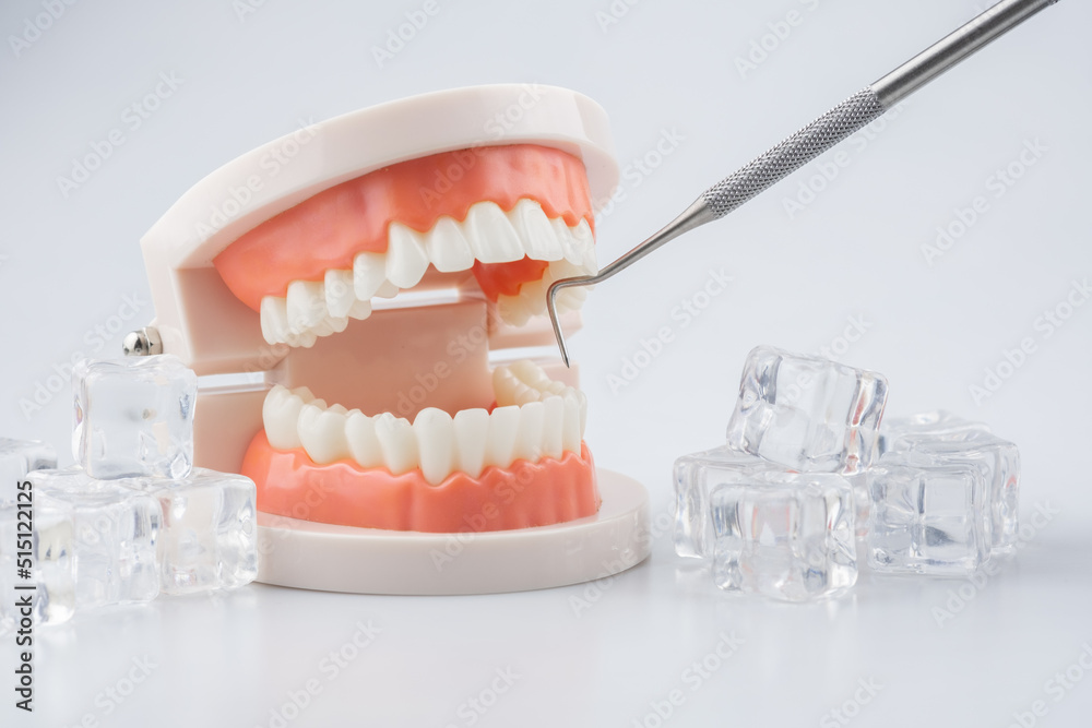 Tooth model with ice cubes and dental scaling tools, the concept of ...
